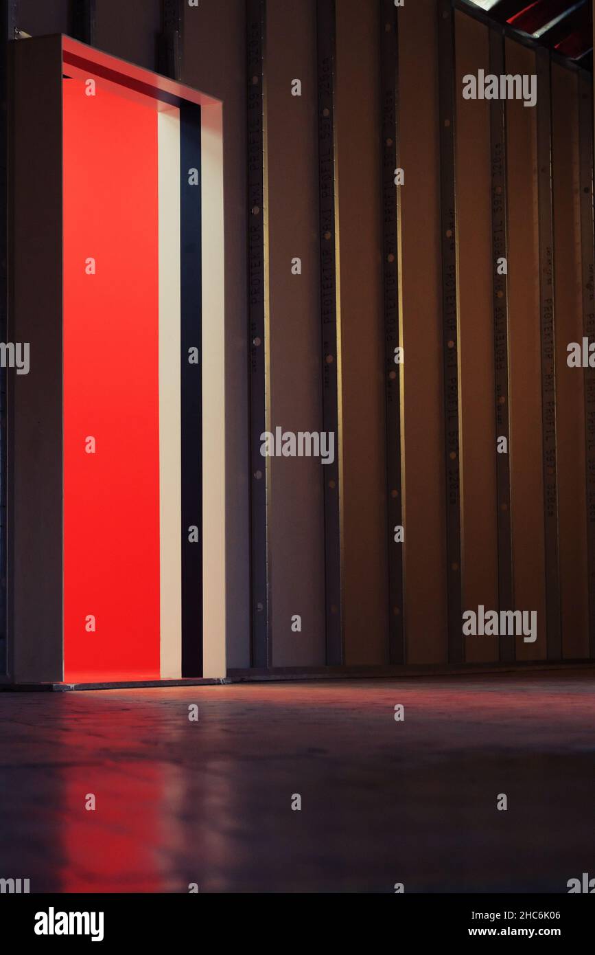 Vertical shot of a hallway illuminated with red light from the doorway ...