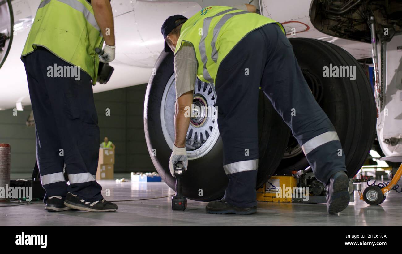 Airport worker checking chassis. Engine and chassis of the passenger ...