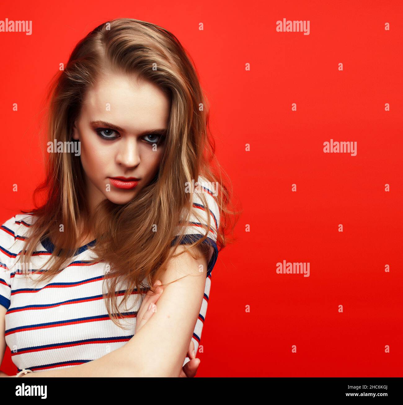 young pretty emitonal posing teenage girl on bright red background ...