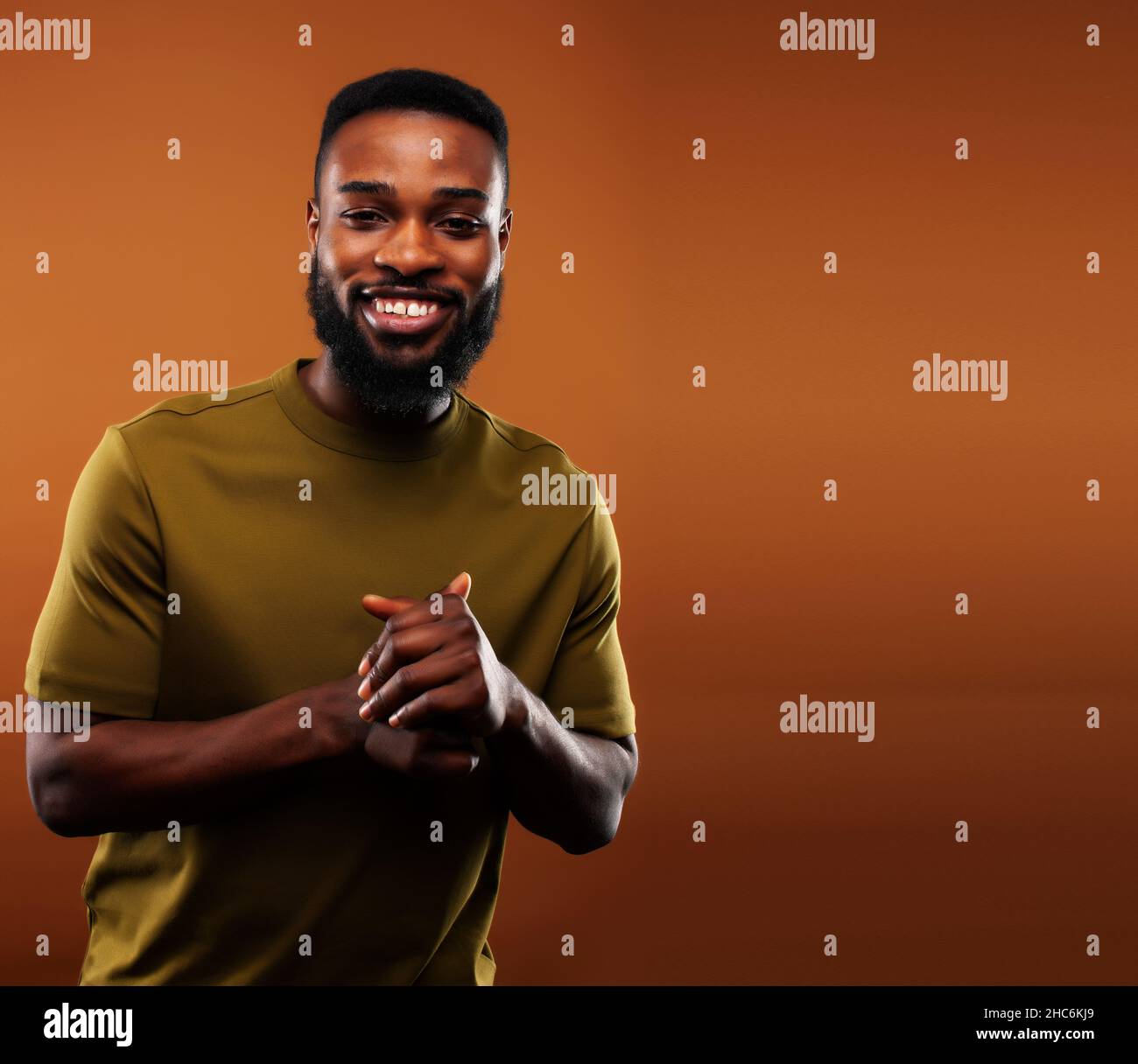 young pretty african american man posing cheerful on brown background, lifestyle people concept ...