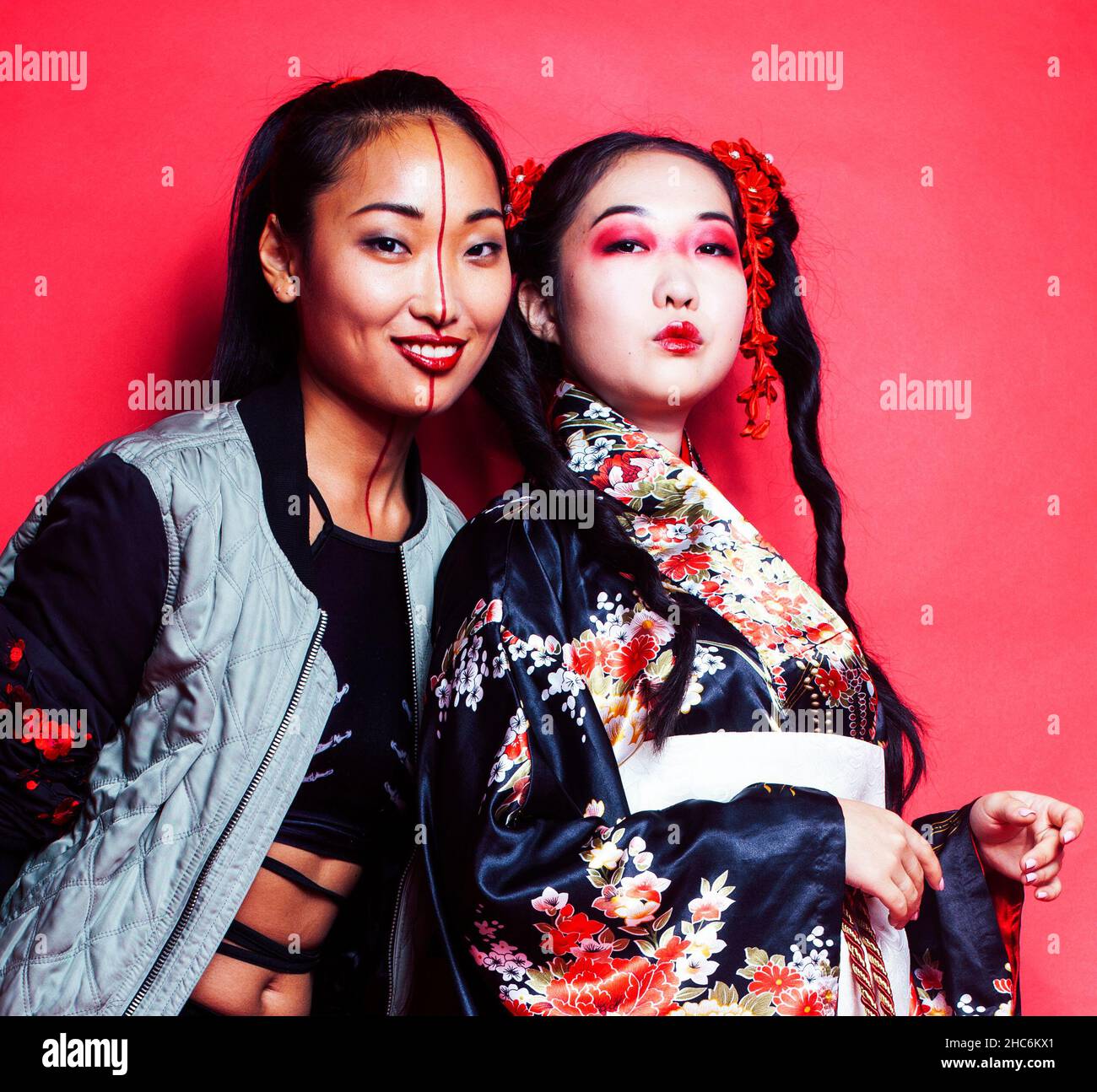 two pretty geisha friends: modern asian woman and traditional wearing ...
