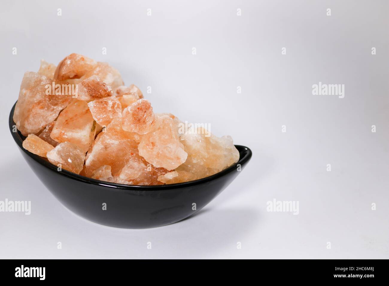 Pink himalayan salt blocks in black bowl with copy space on white ...