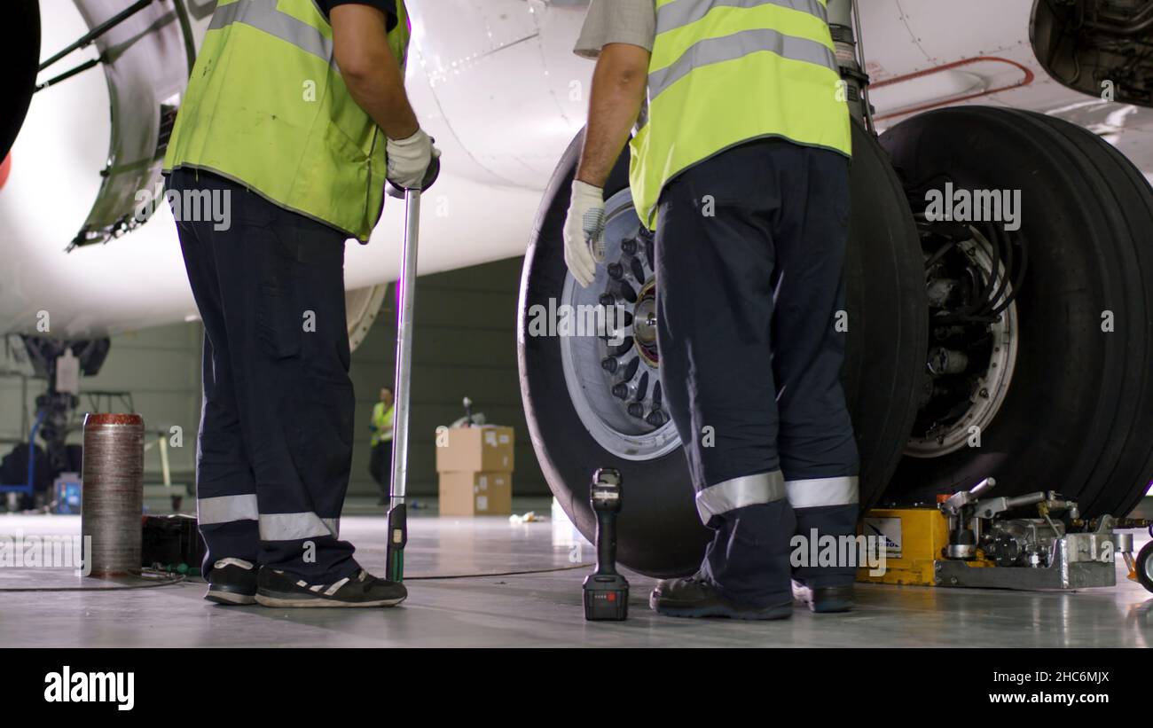 Airport worker checking chassis. Engine and chassis of the passenger ...