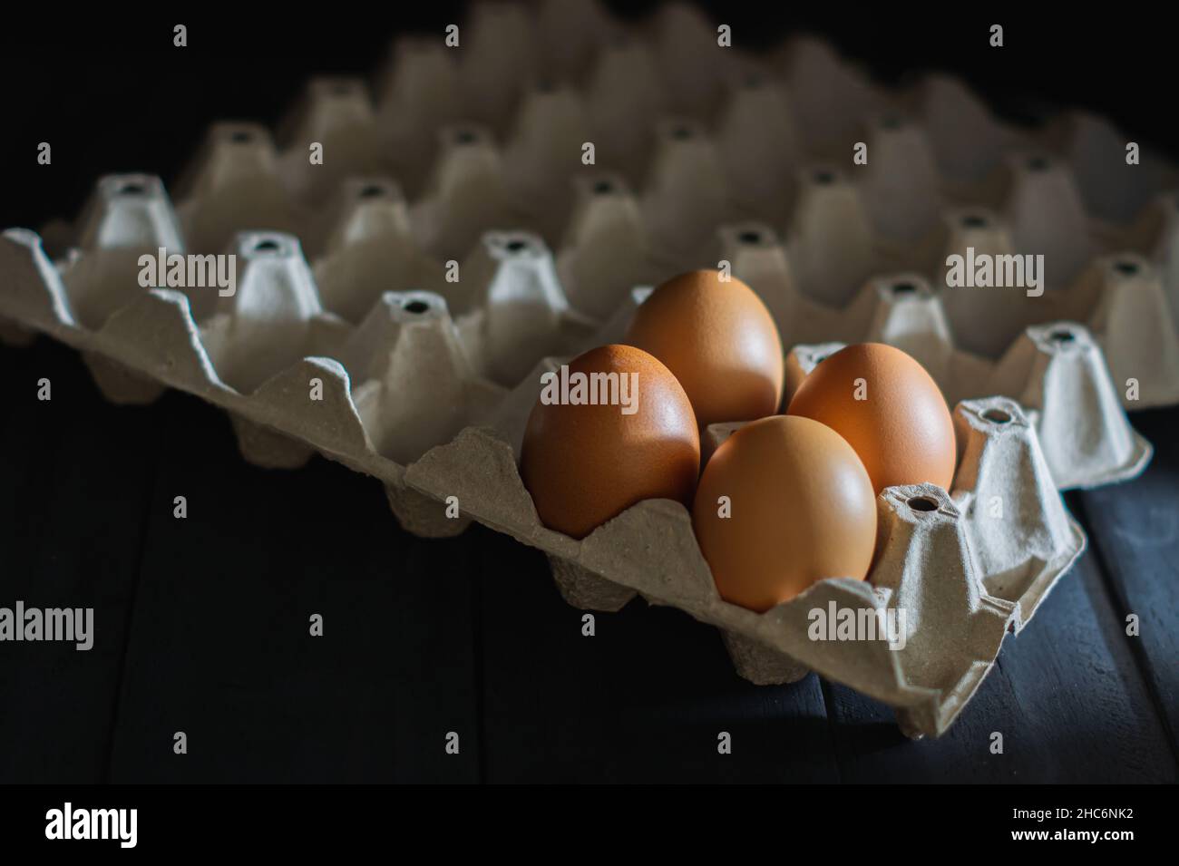 The front image of four fresh eggs is placed on a paper egg panel with ...