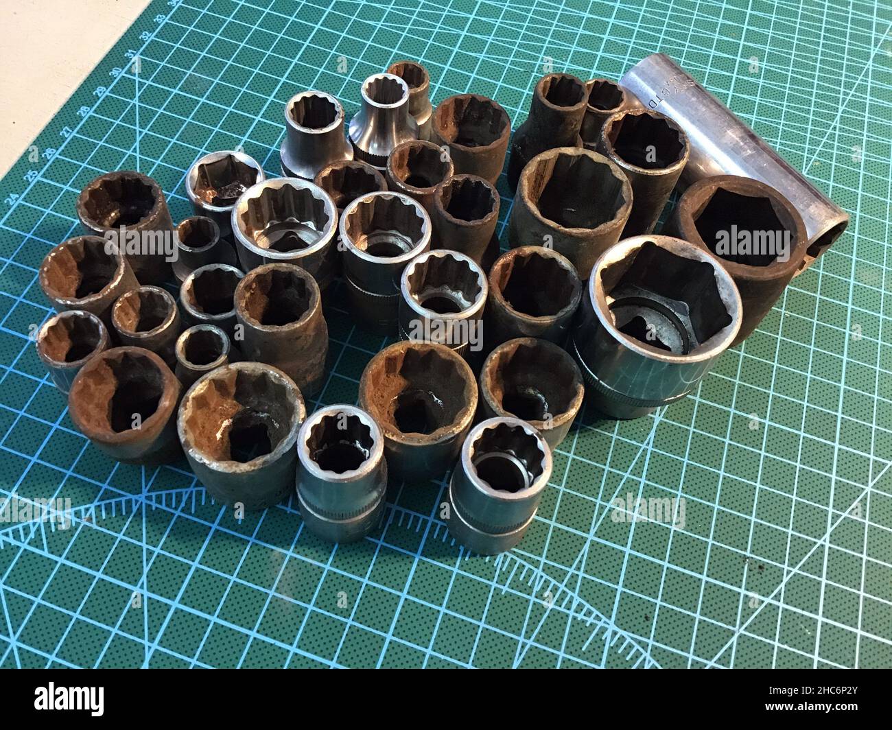 Closeup shot of rusty old and new steel hex sockets on the green ...