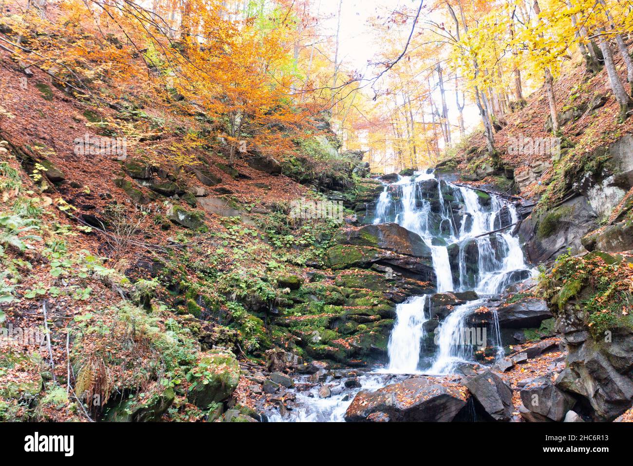 Cold stream falling down rocks and stones of mountain slope through ...