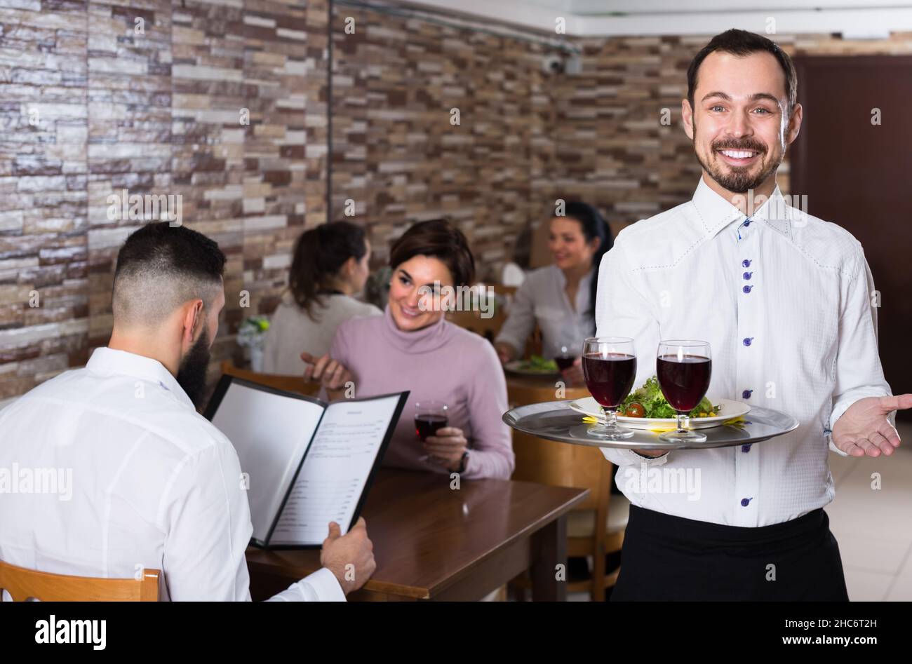 Portrait of adults in middle class restaurant and friendly waiter Stock ...