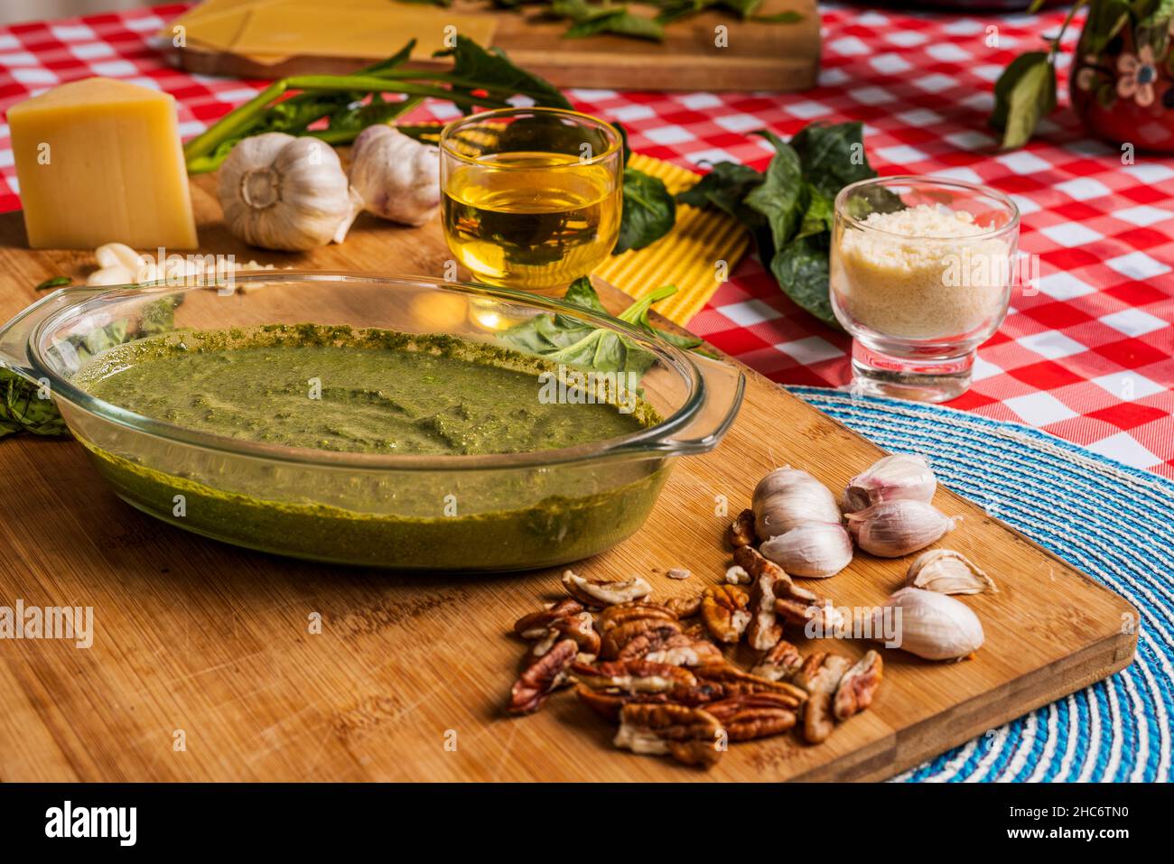 Pesto sauce in a glass container with the different ingredients that ...