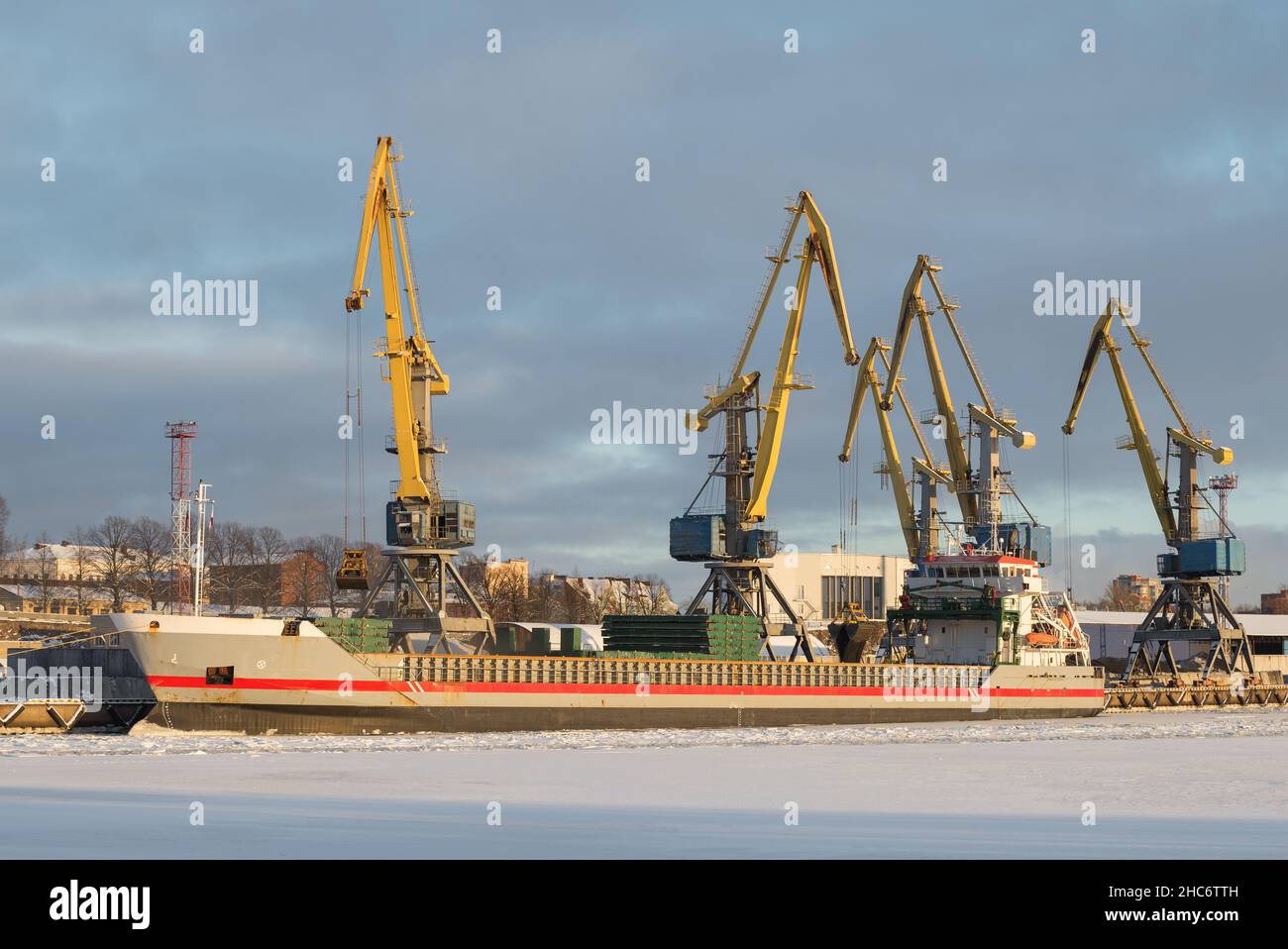A cargo ship loading on the Vyborg commercial port on a February ...