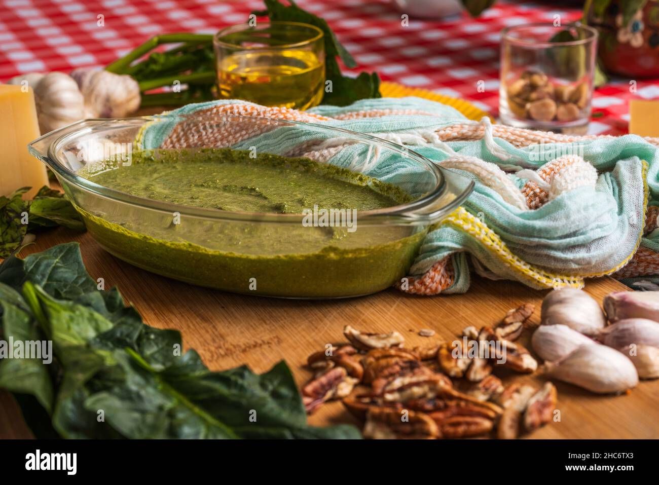 Pesto sauce in a glass container with the different ingredients that ...