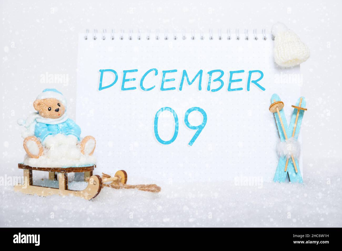 December 9th. Teddy bear sitting on a sled, blue skis and a calendar ...