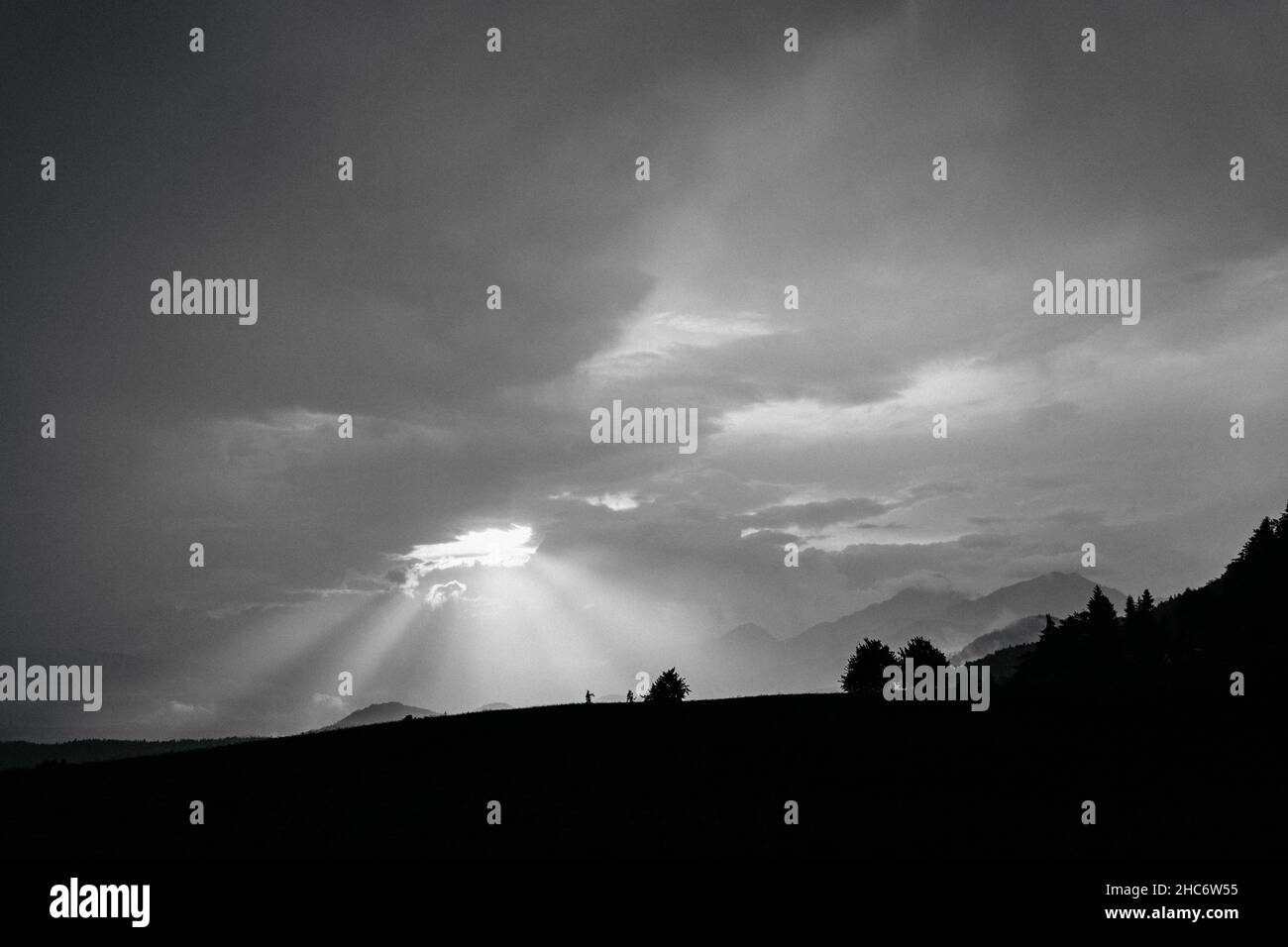 Beautiful grayscale view of the hills gleaming under the cloudy sky ...