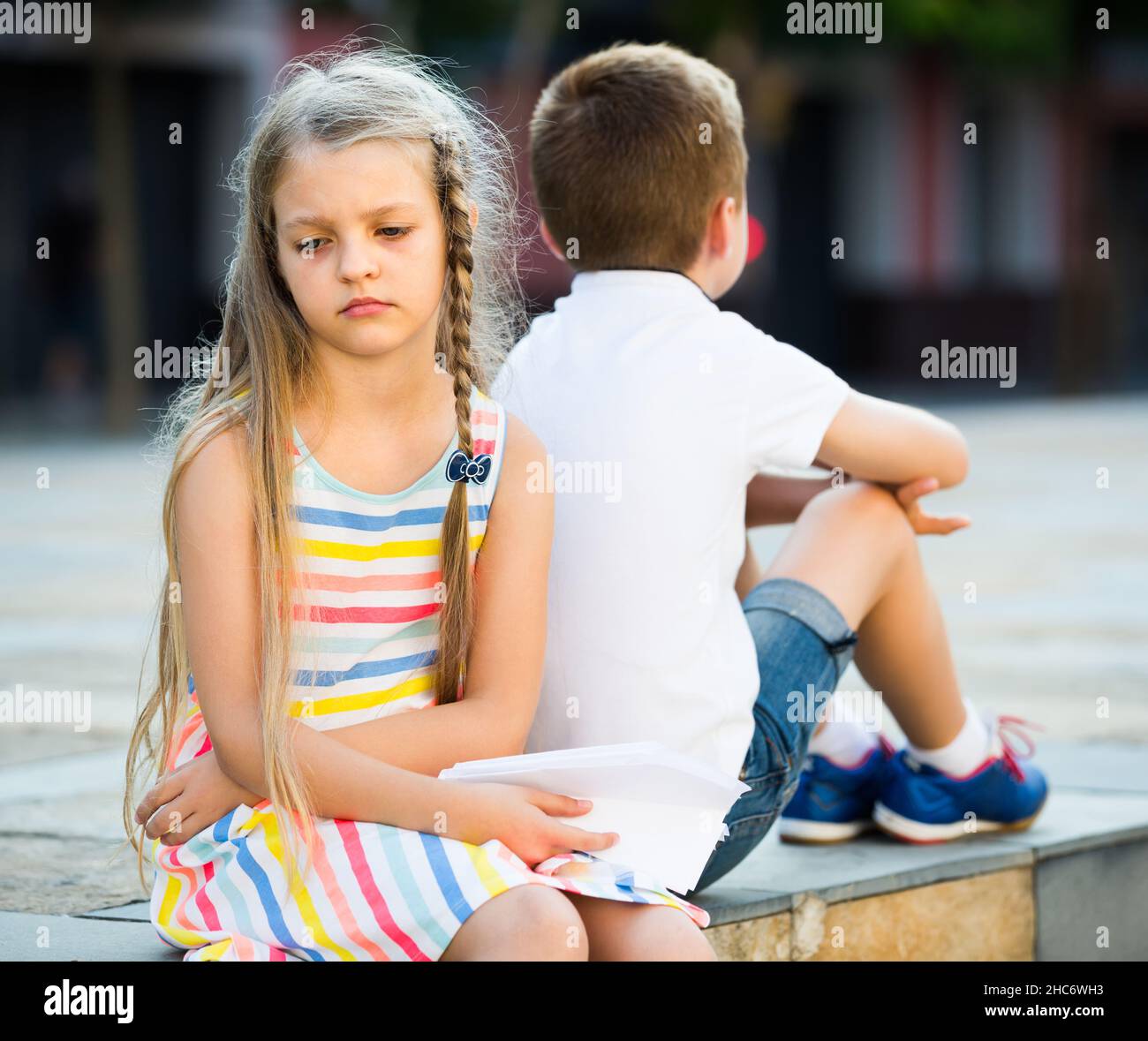 sad girl sitting back to friend outdoor Stock Photo - Alamy