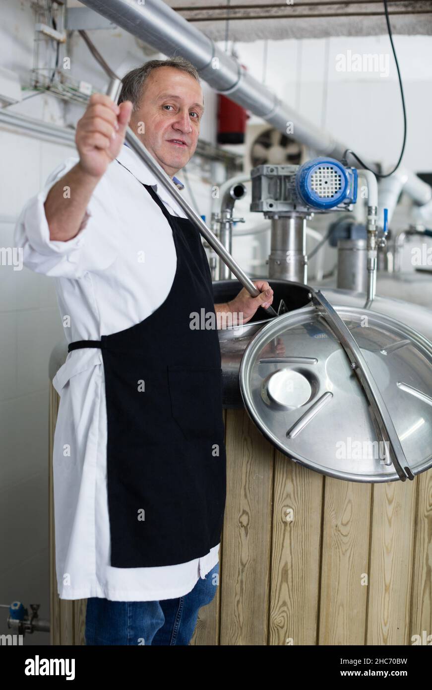 Brewer is controls the brewing process near reservoir with beer Stock ...