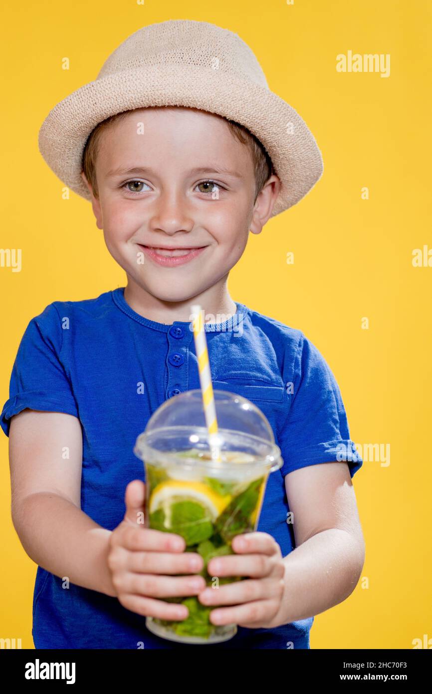 Cute boy Drink Mojito cocktail From Plastic Cup Over Yellow Studio ...