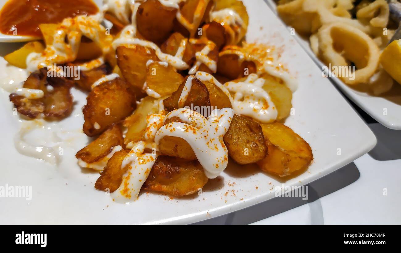 Typical Spanish tapas (patatas bravas) fried with various types of ...