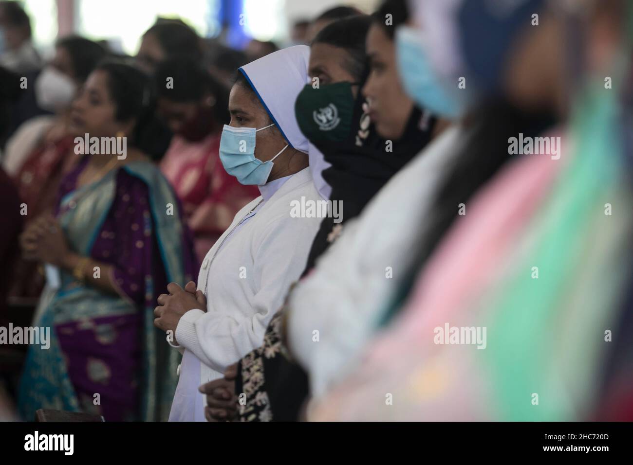 Christian Devotees wearing masks attend prayers at a Holy Rosary ...