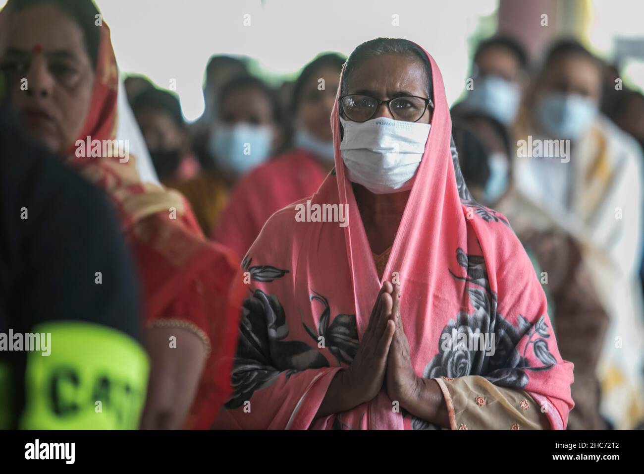 A Christian Devotee wearing a masks attend prayers at a Holy Rosary ...