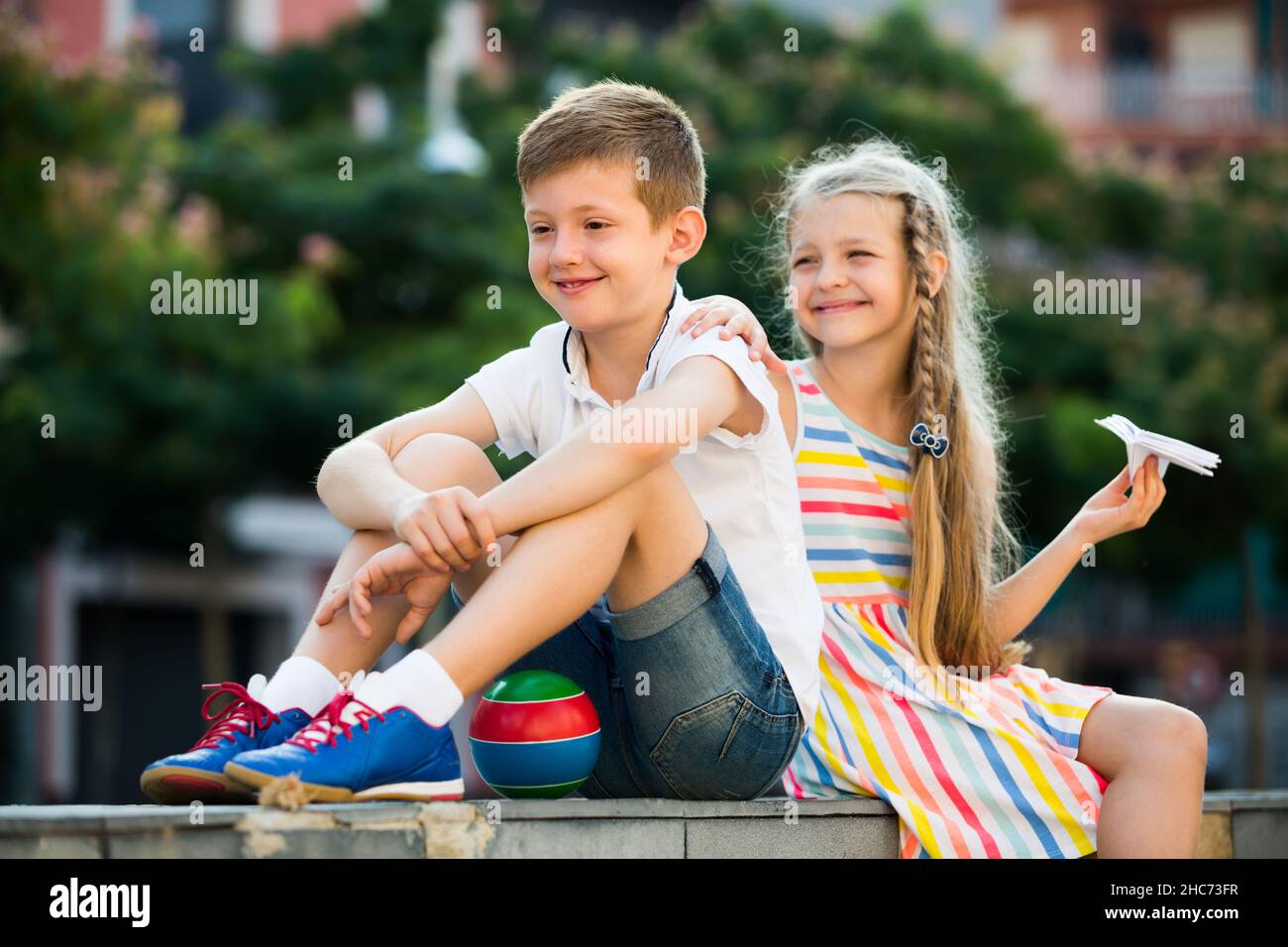 Two kids sitting together outdoor Stock Photo - Alamy