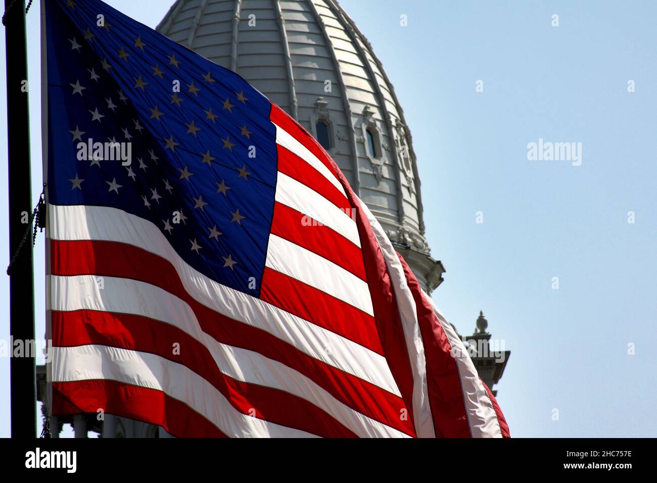 The Michigan State Capitol building, partially obscured by the American ...
