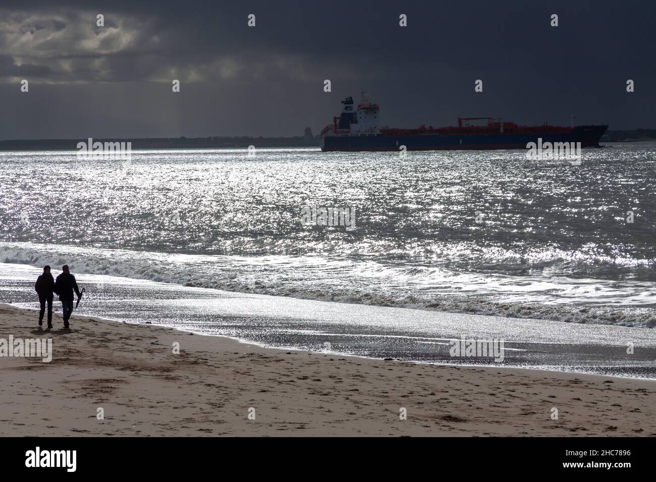 Beautiful view of humans standing on a beach on a rainy day Stock Photo ...