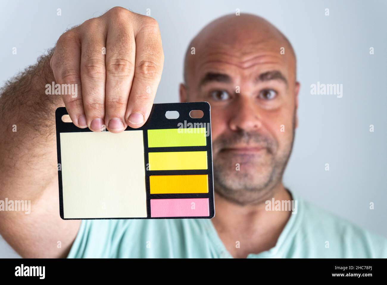 Close-up shot of a Bald and bearded Caucasian man showing memo stickers ...