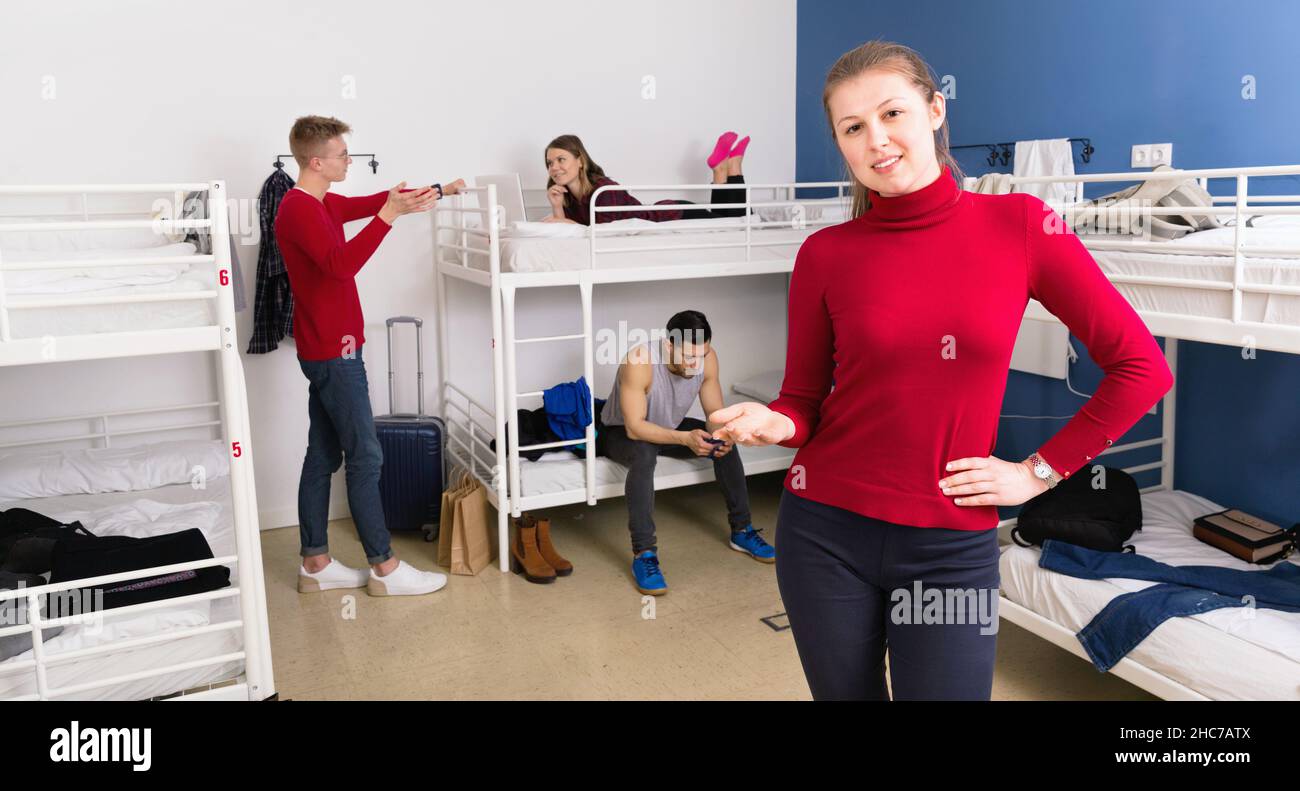 Polite attractive girl welcoming guests in modern hostel Stock Photo ...