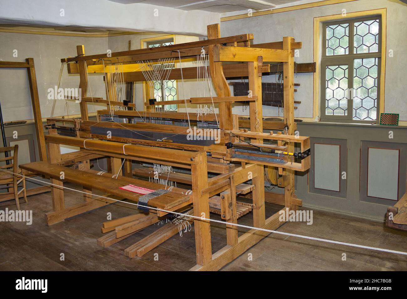 Shot of a wooden shuttle loom machine on a wooden floor in the room ...