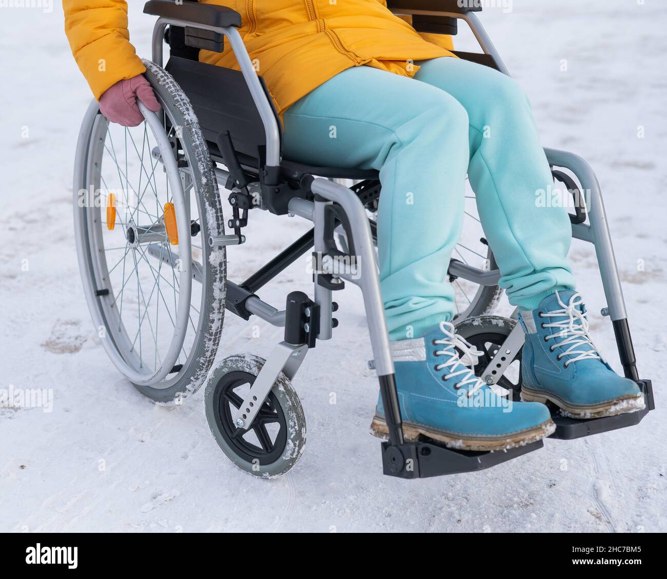 Close-up of hands of a disabled woman in a wheelchair outdoors in ...