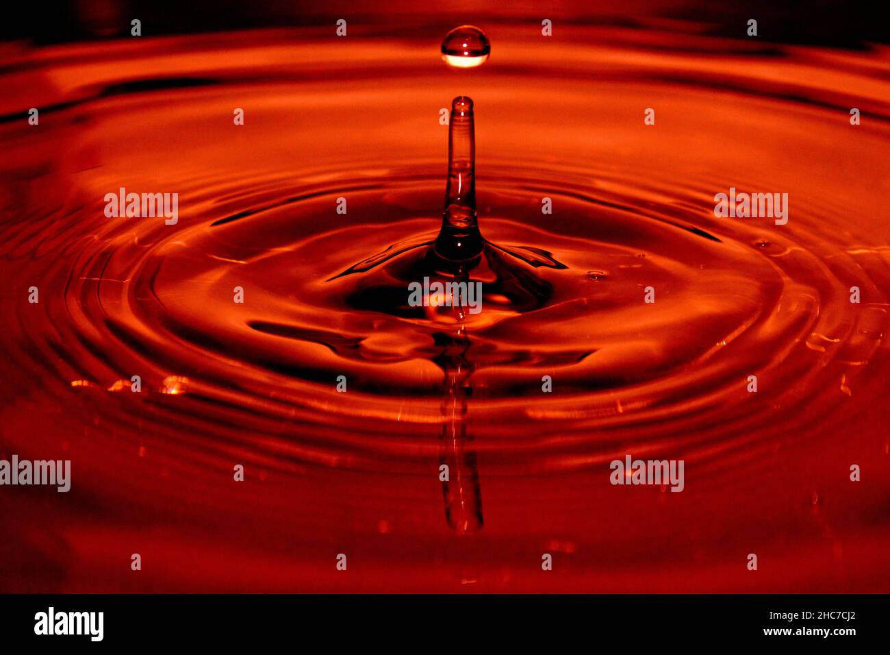 Closeup of water drop splash in the red background Stock Photo - Alamy