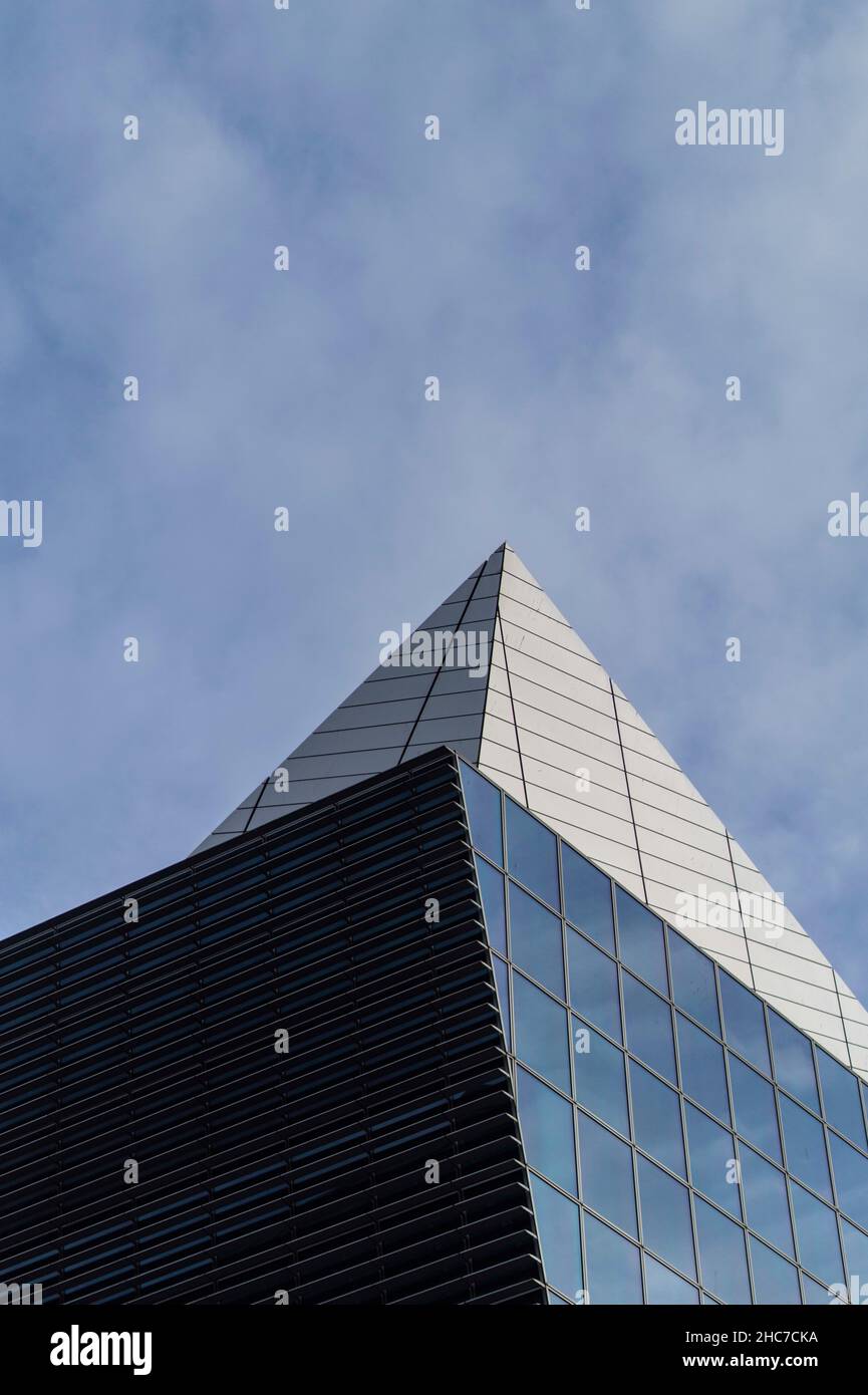 Vertical shot of triangle-shaped building in background of a glassy ...