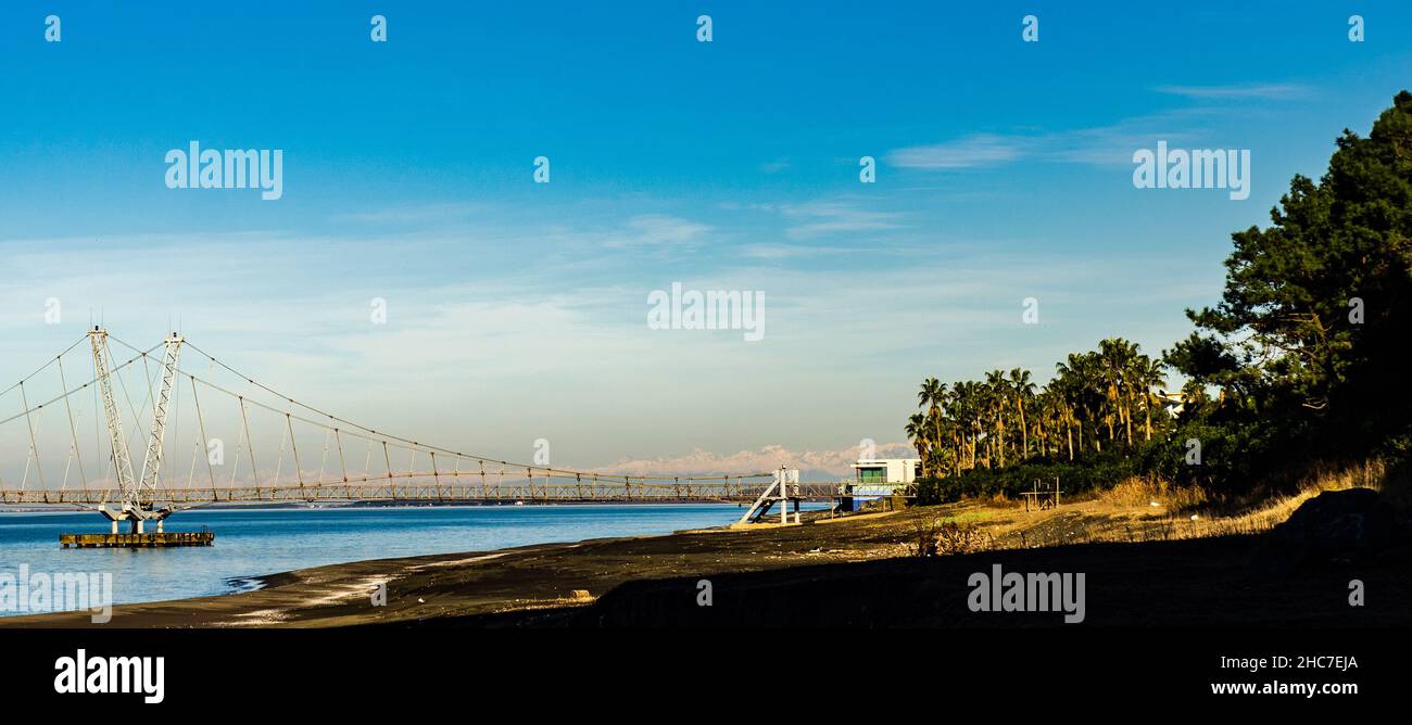 Black volcanic sand beach and Caucasus mountains with snow peaks in ...