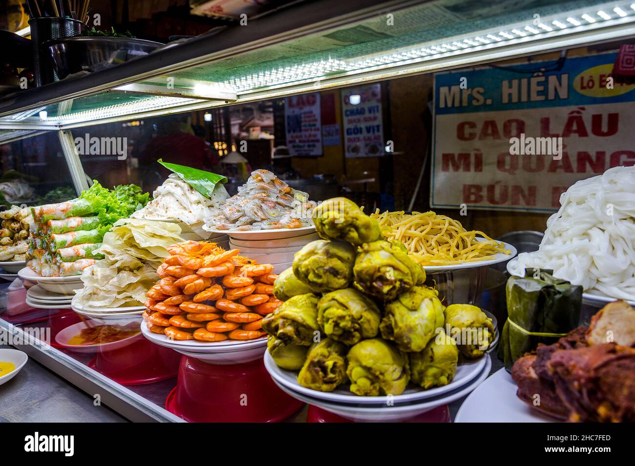Plates in a food display counter where the food is piled high on the ...