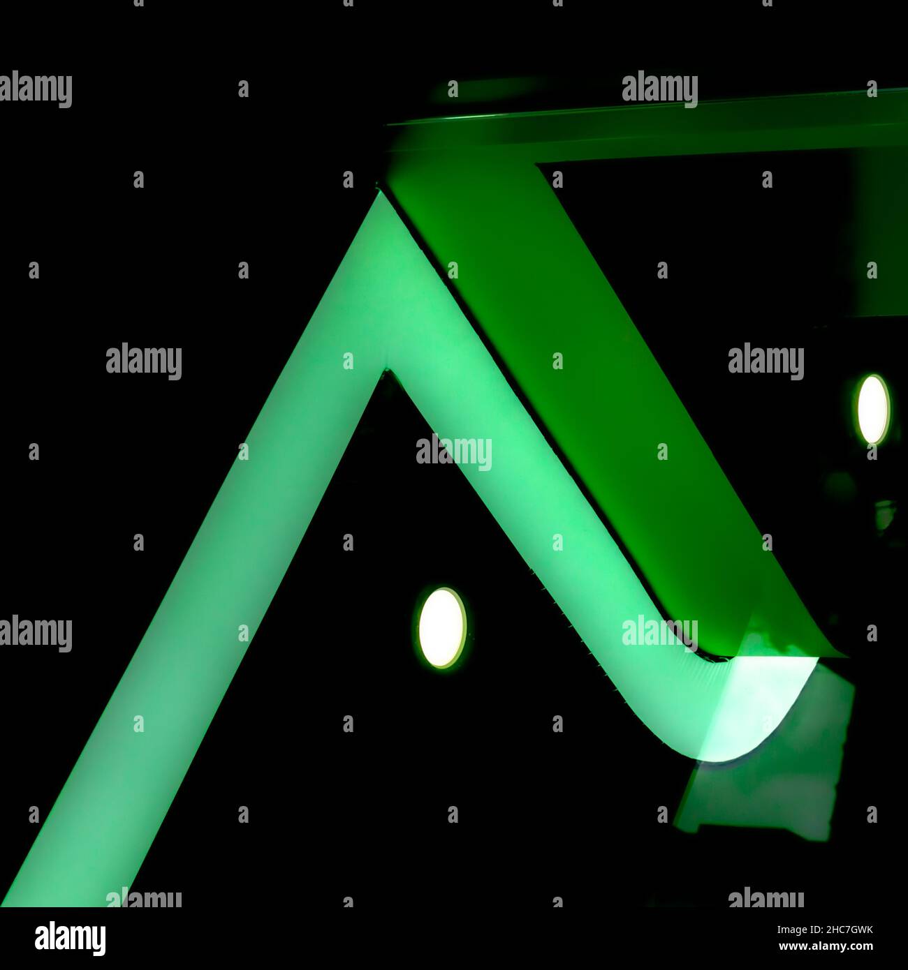 Green light falling on the angle of a wall on dark background Stock ...