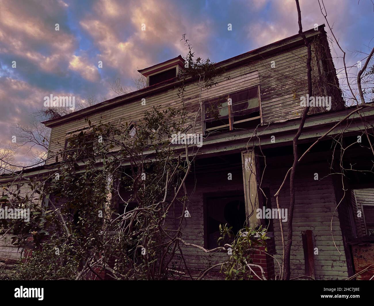 Old creepy scary wooden overgrown abandoned mansion in rural Georgia ...