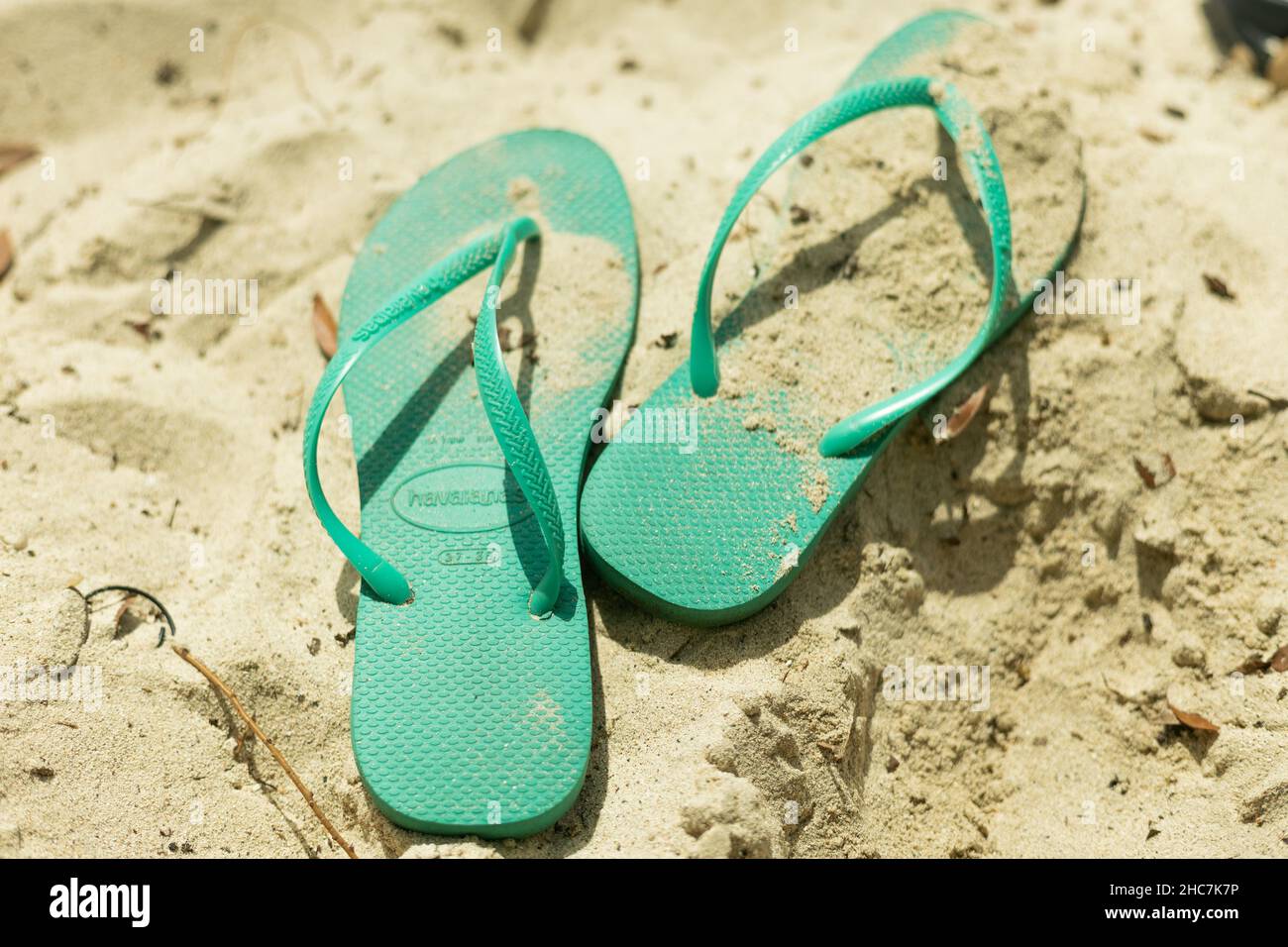Pair of beach slippers on the sand Stock Photo - Alamy
