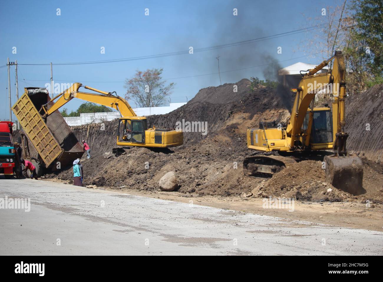 heavy equipment excavator which is stirring the soil and making holes ...