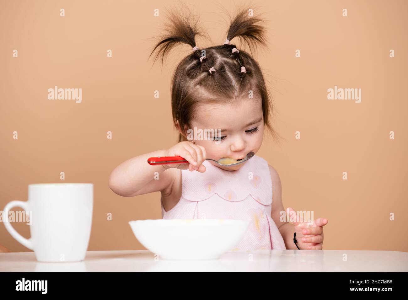 Kid eat healthy nutrition, baby food. Babies eating with spoon. Lick ...