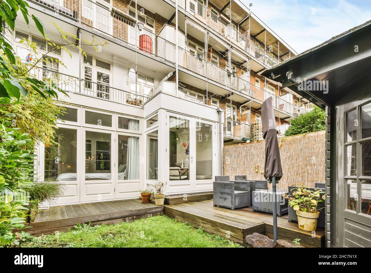 View of a cozy courtyard of the house with glass doors to the house ...