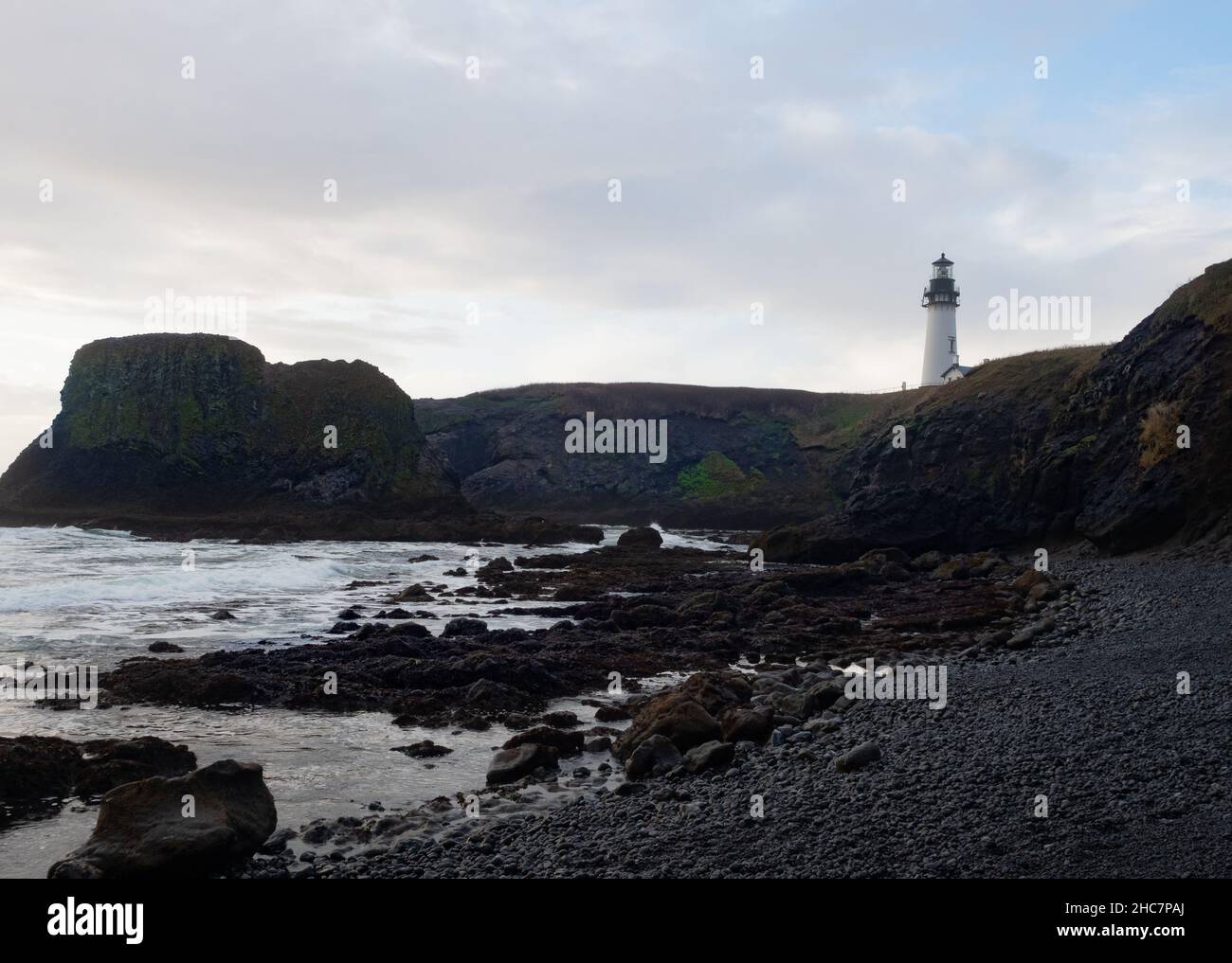 The black cobblestone beach and volcanic rock boulders with Yaquina ...