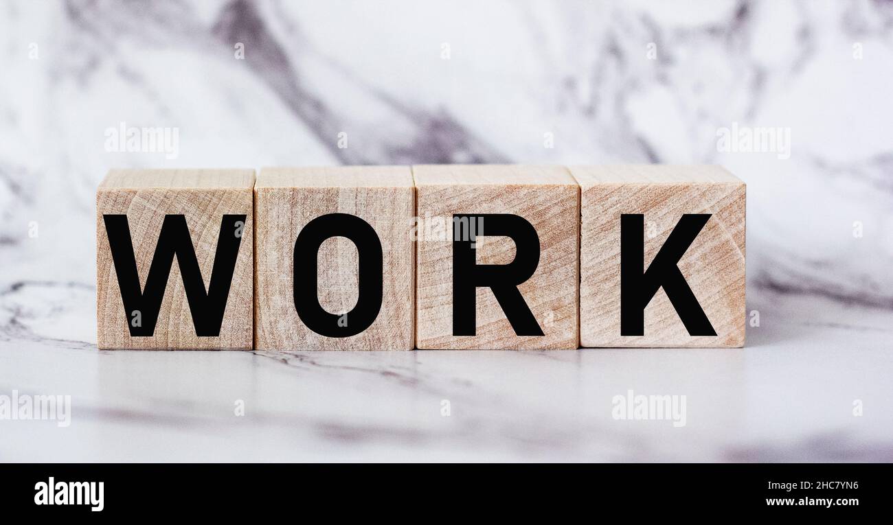 The word WORK is written in wooden cubes with black letters on the ...