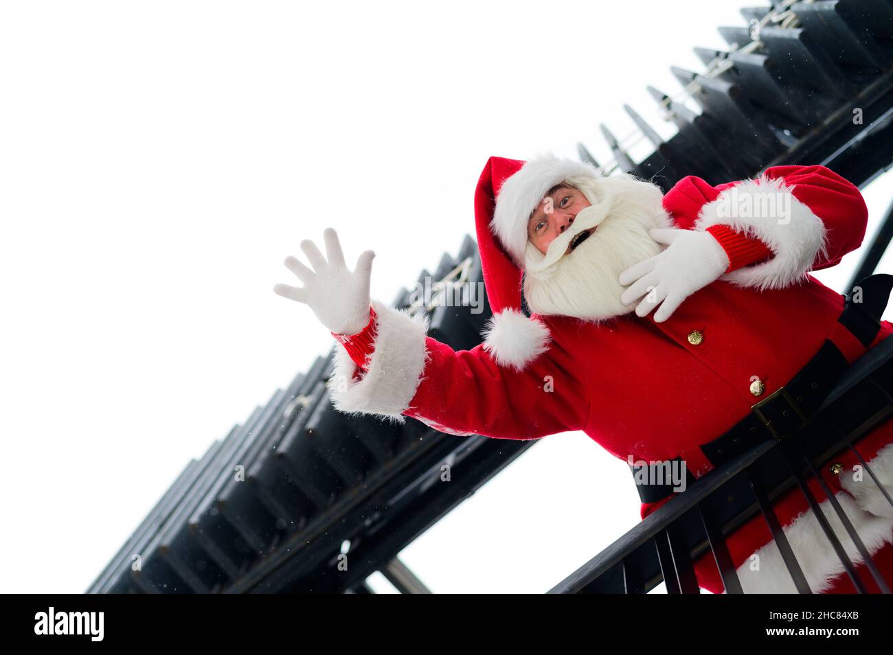 Santa claus looks down from the stairs and wishes a merry christmas ...