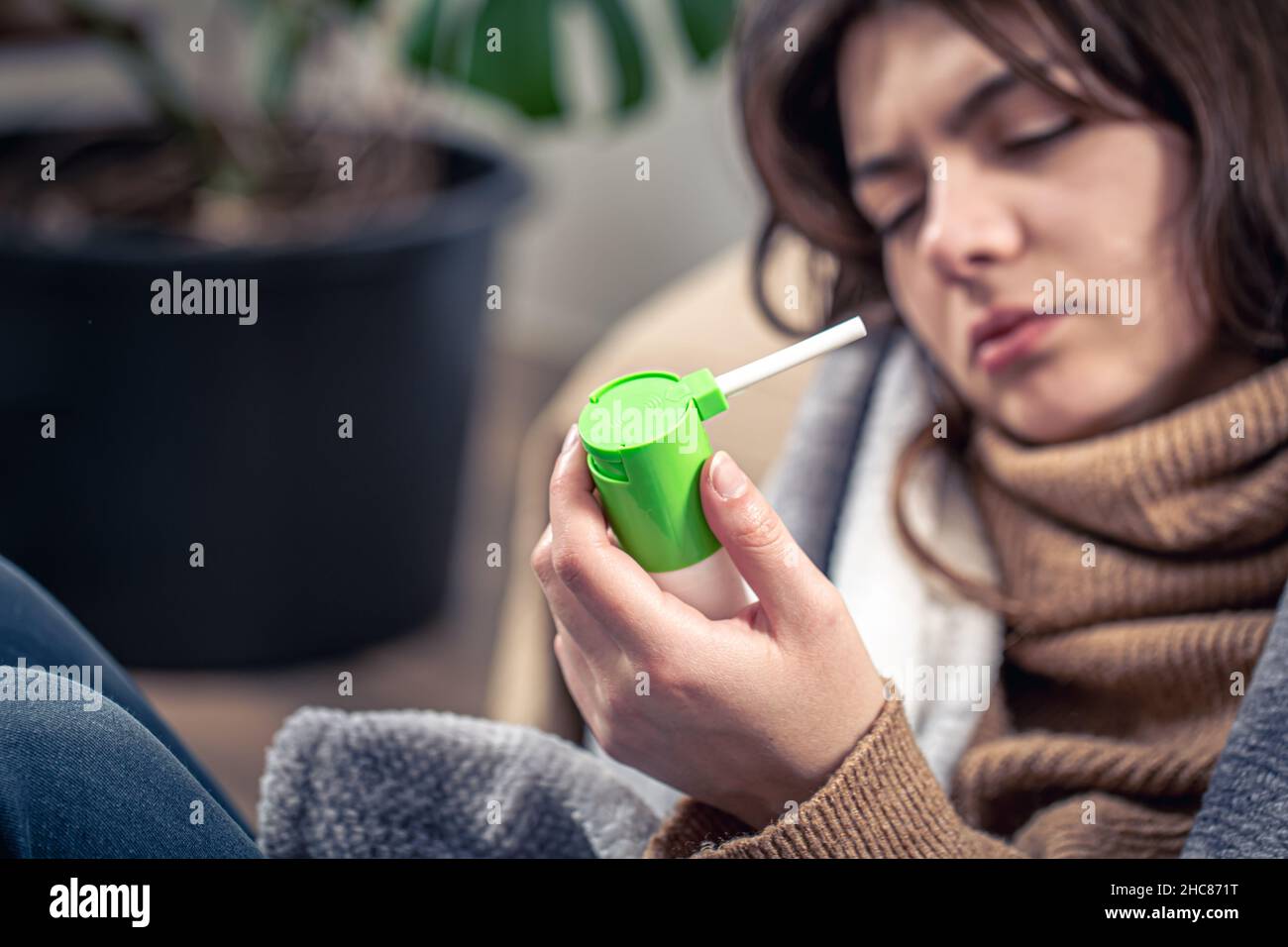 A sick young woman using cough spray Stock Photo - Alamy