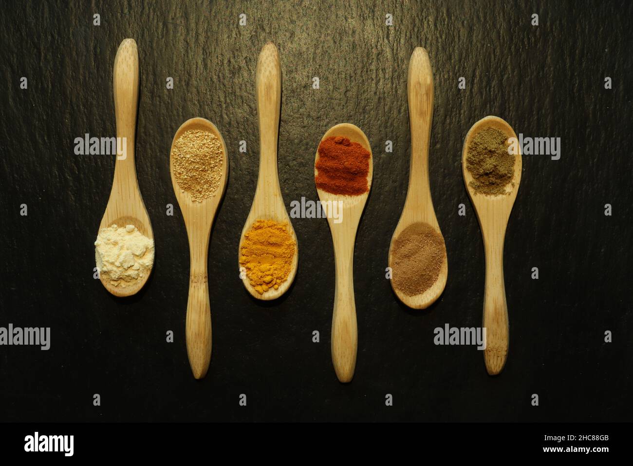 Photography of powder spices in little wooden spoons on a slate for ...