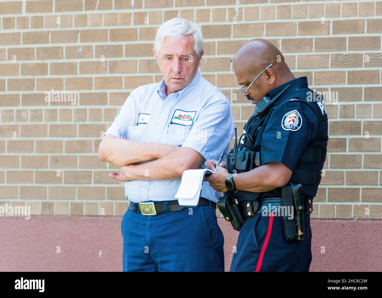 Toronto Police officer interviewing a witness in crime scene, Toronto ...