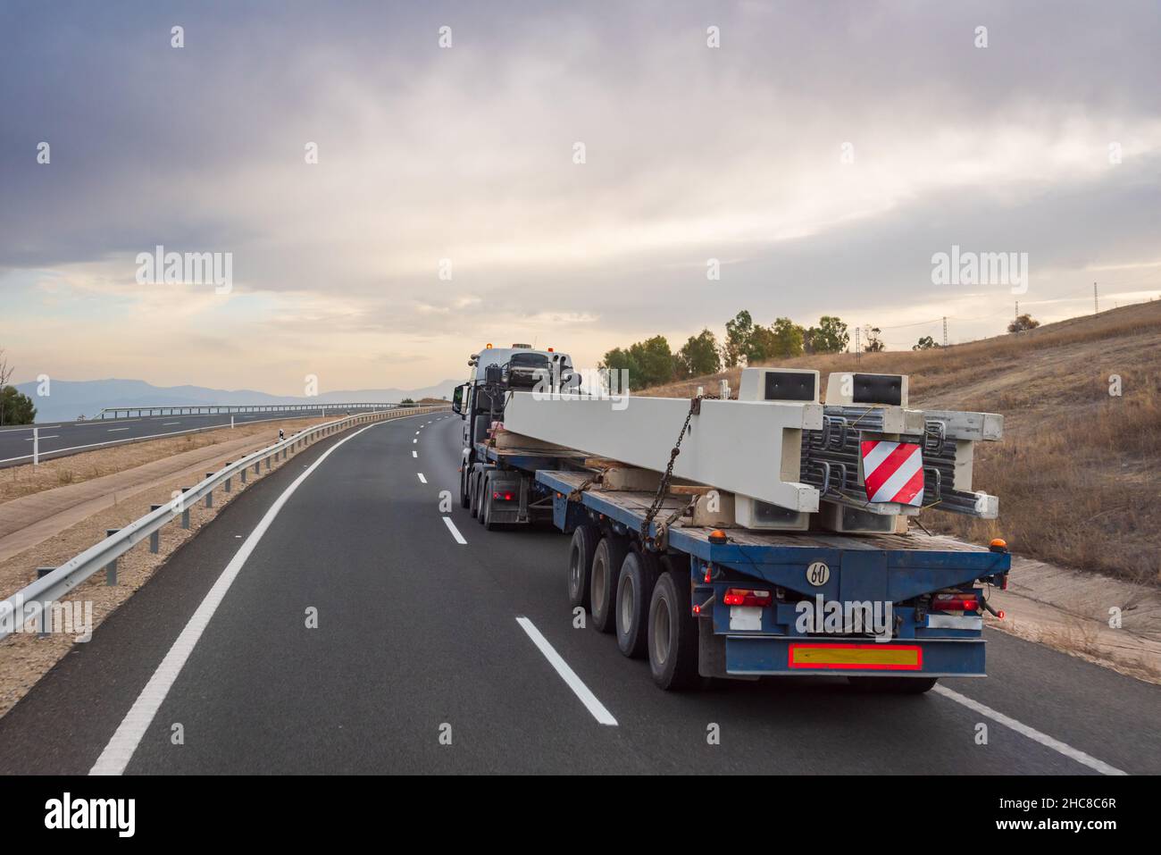 Special transport carrying columns circulating on a cloudy day Stock ...