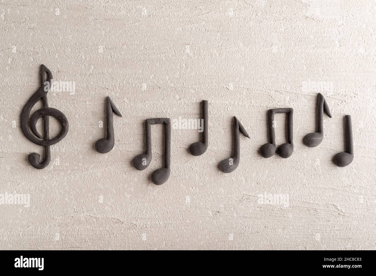 Black music violin clef sign and note on rough beige surface. G-clef ...