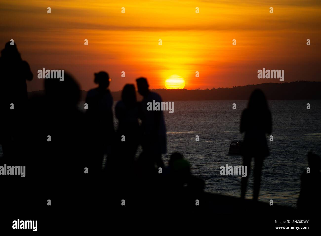 Silhouette of people enjoying the wonderful colorful sunset of Farol da ...