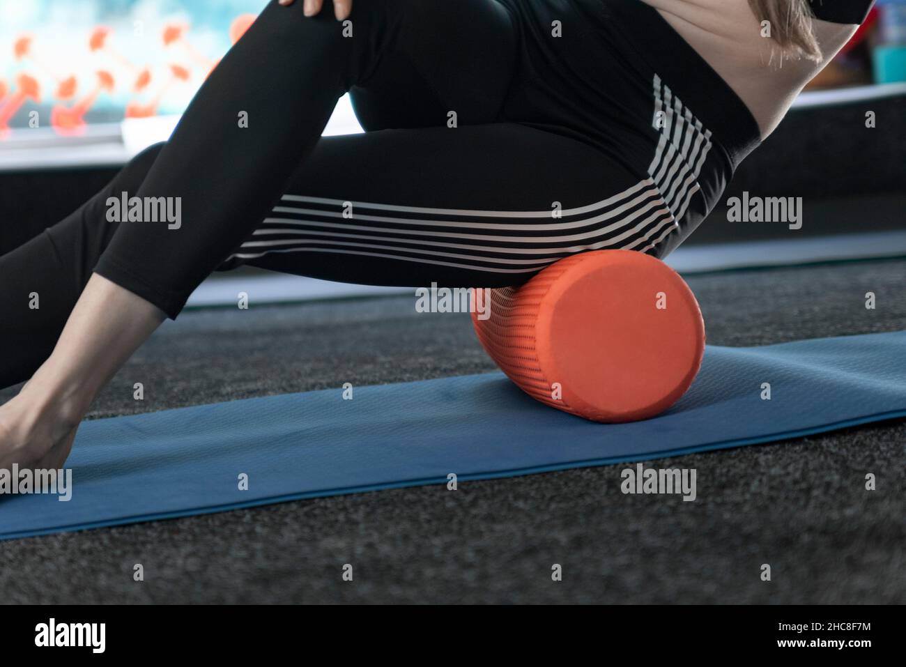 Girl kneads the thigh muscles with an MFR roller. Myofascial release ...