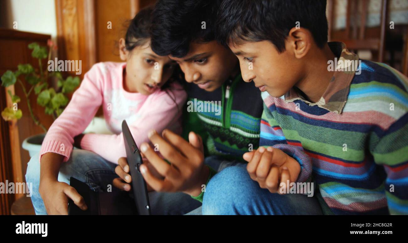 Beautiful shot of South Asian children playing a game with tablet Stock ...